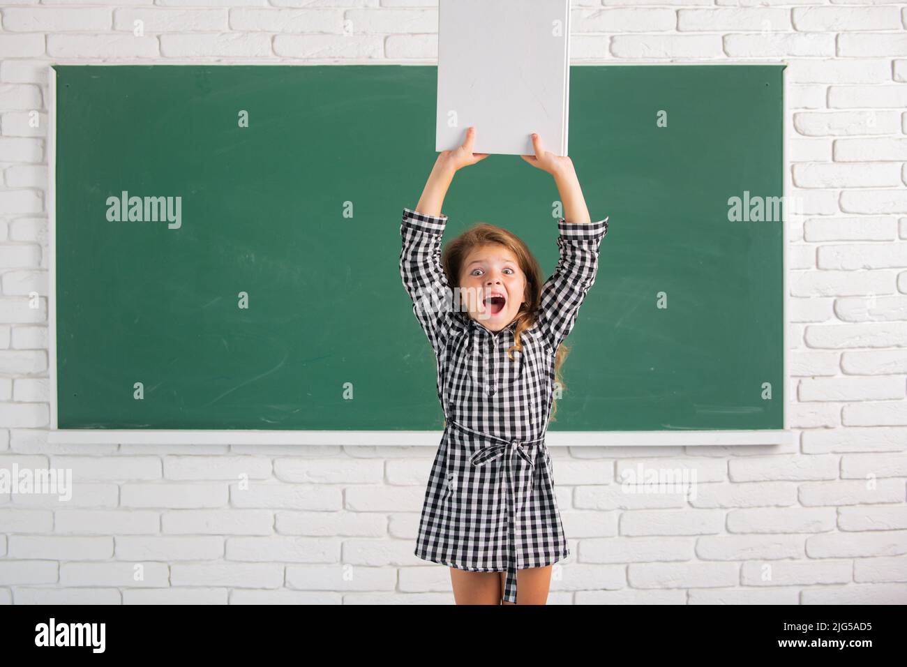 Excited child at school. Amazed kid in class on background of ...