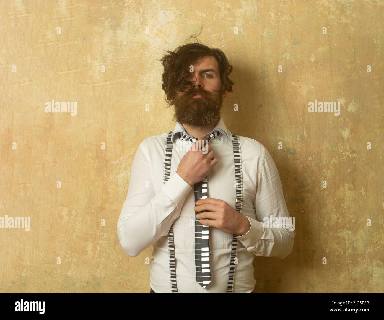 Crazy man with suspenders feel candid face expression. Portrait of funny bearded man in white ...