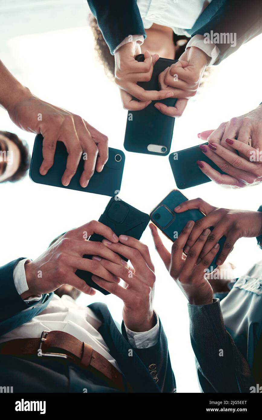 Networking. Low angle shot of a group of unrecognisable businesspeople ...
