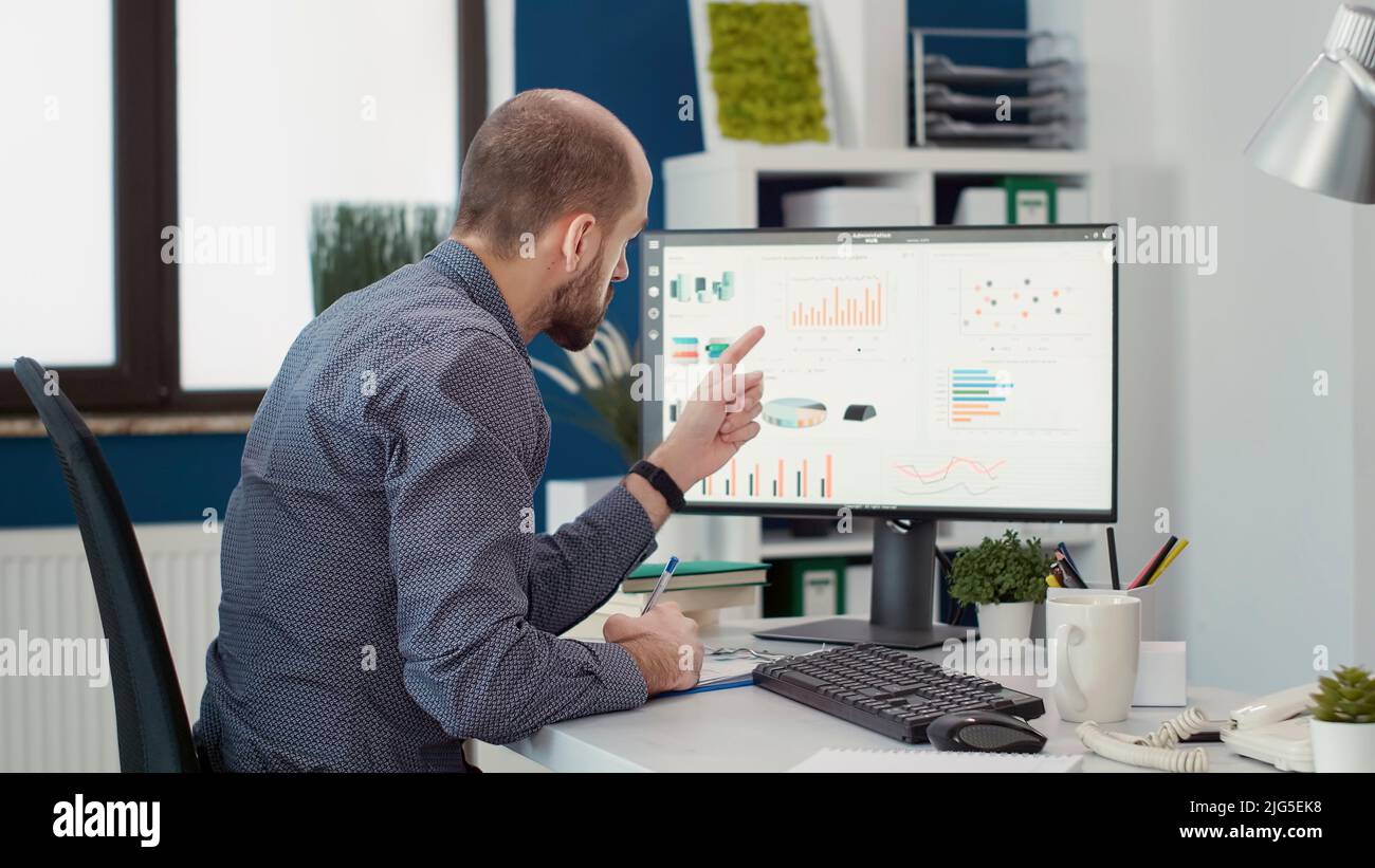 Company accountant analyzing business charts and sales data on computer ...
