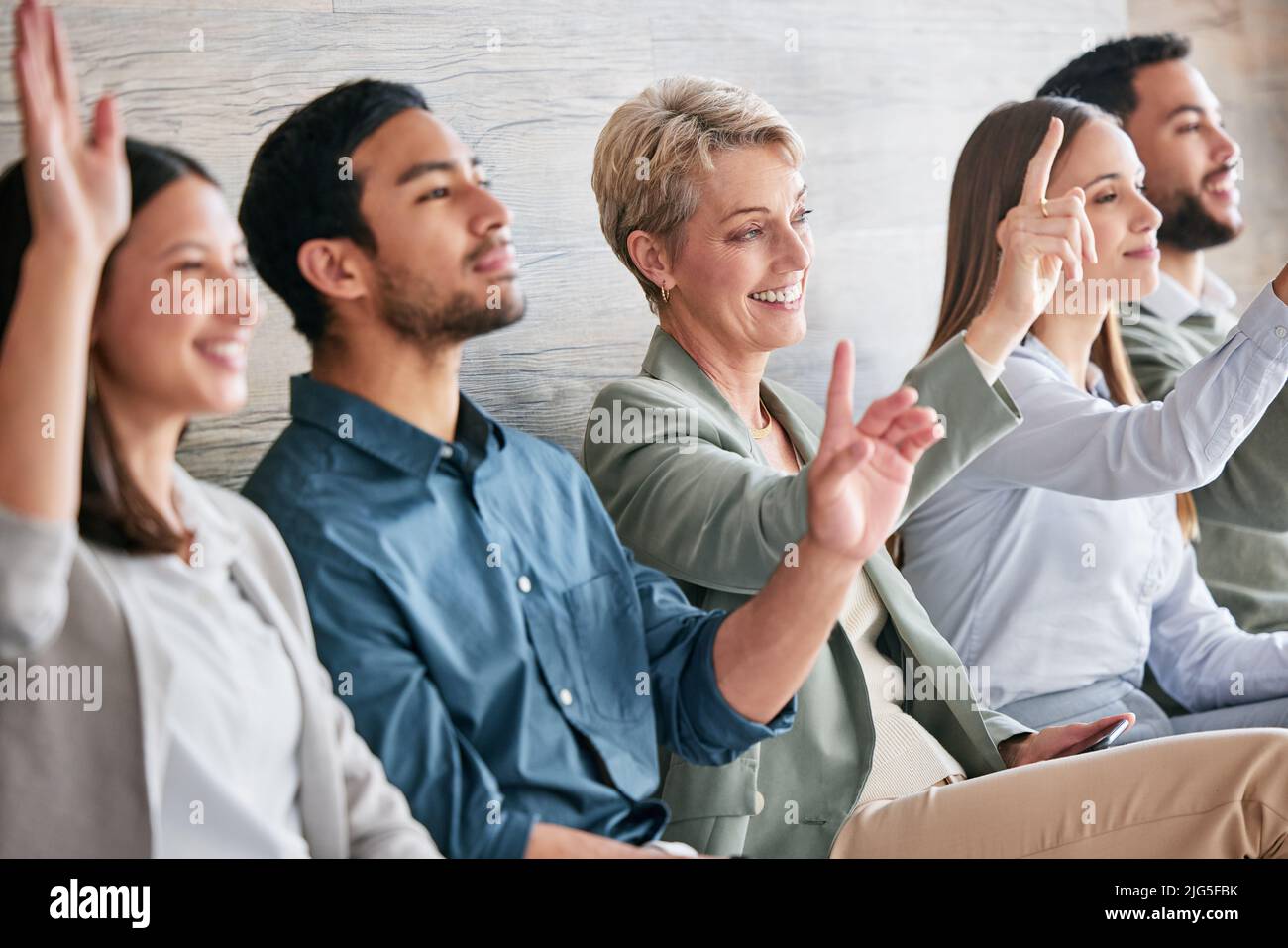We have questions. Shot of a diverse group of businesspeople sitting in ...