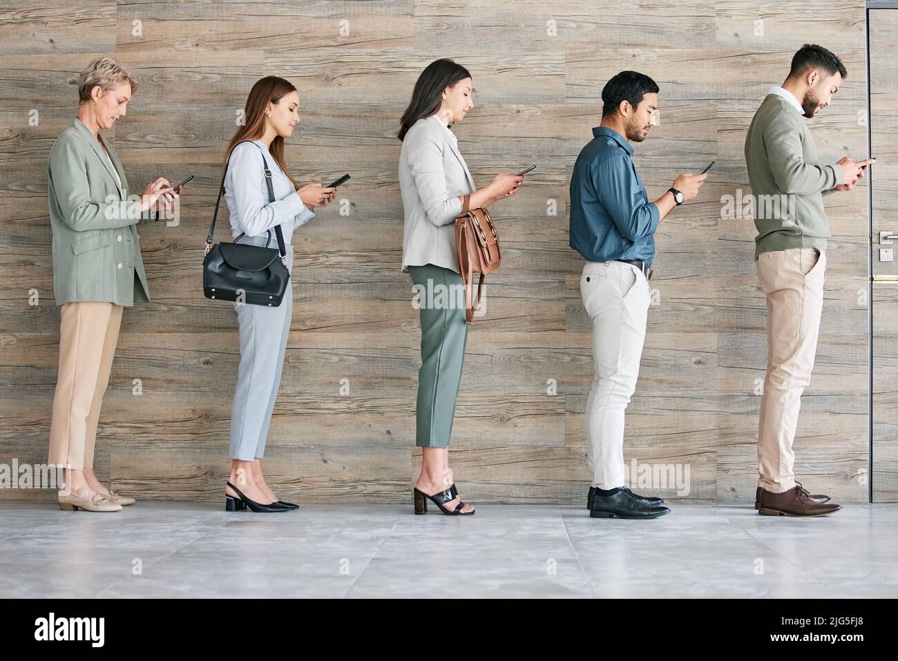 Technology helps with the wait. Full length shot of a diverse group of ...