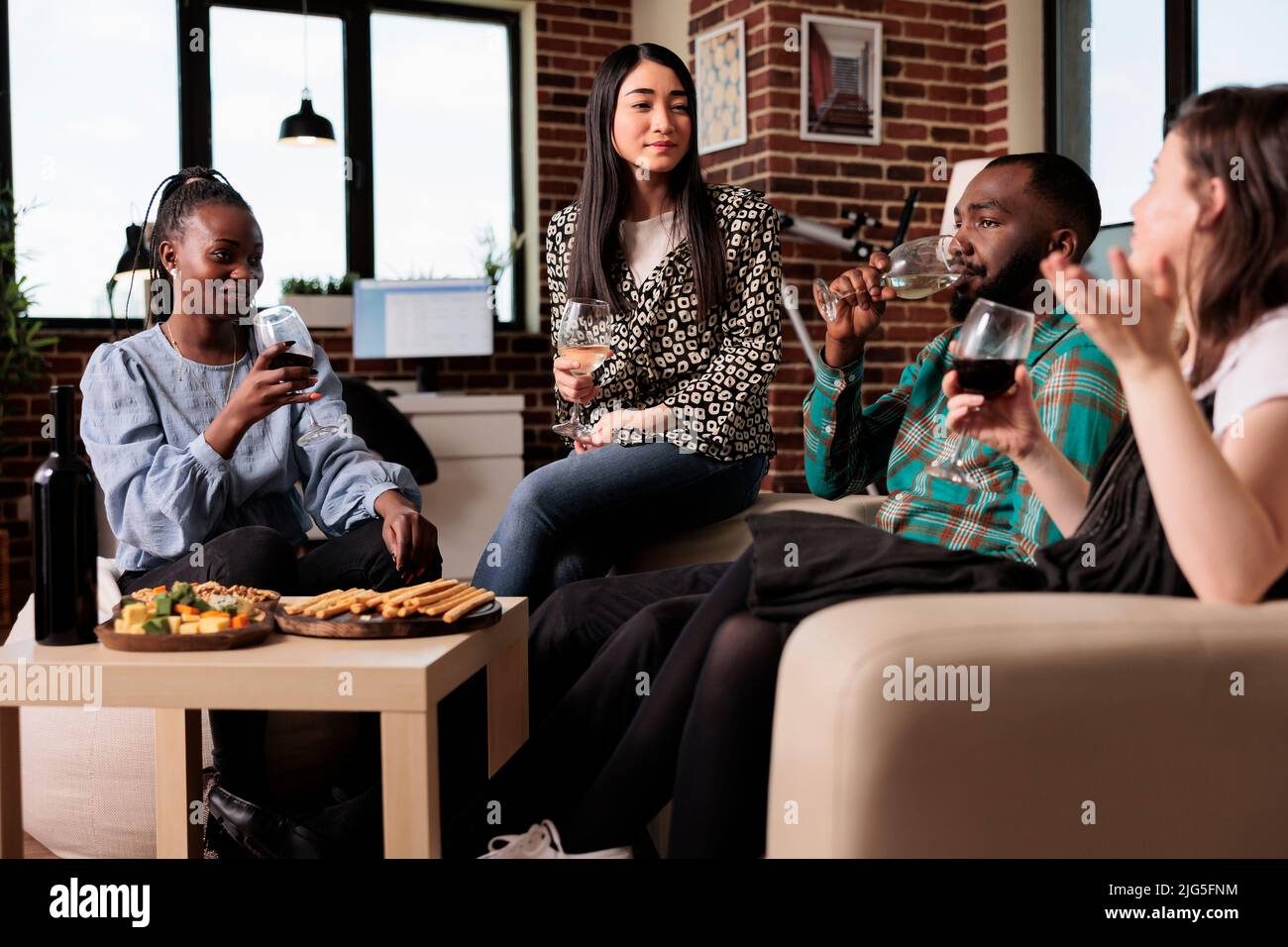 Happy young people enjoying drinking alcohol beverages together while ...