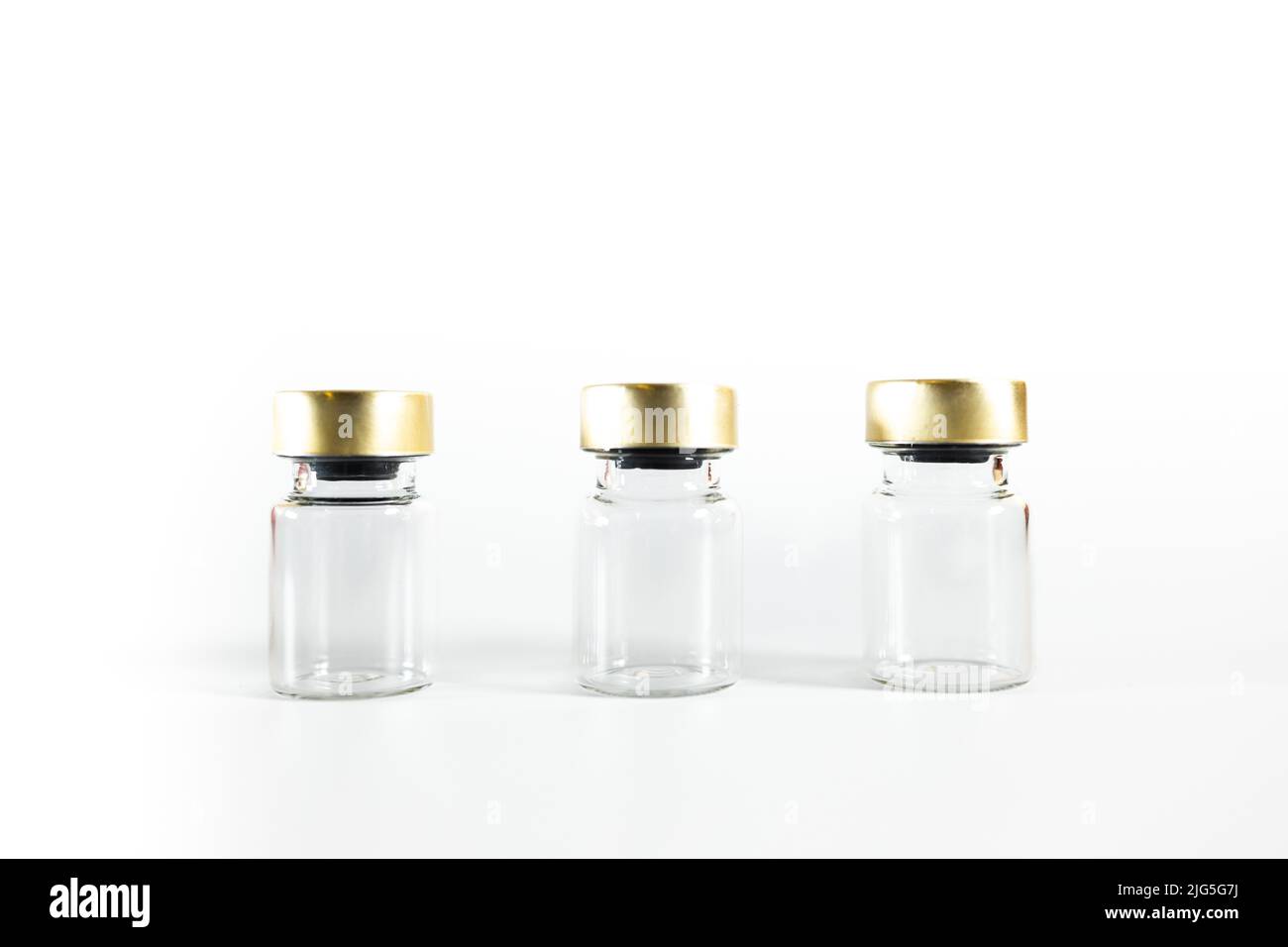 Three small empty glass vials on a white background. Medicine bottles ...