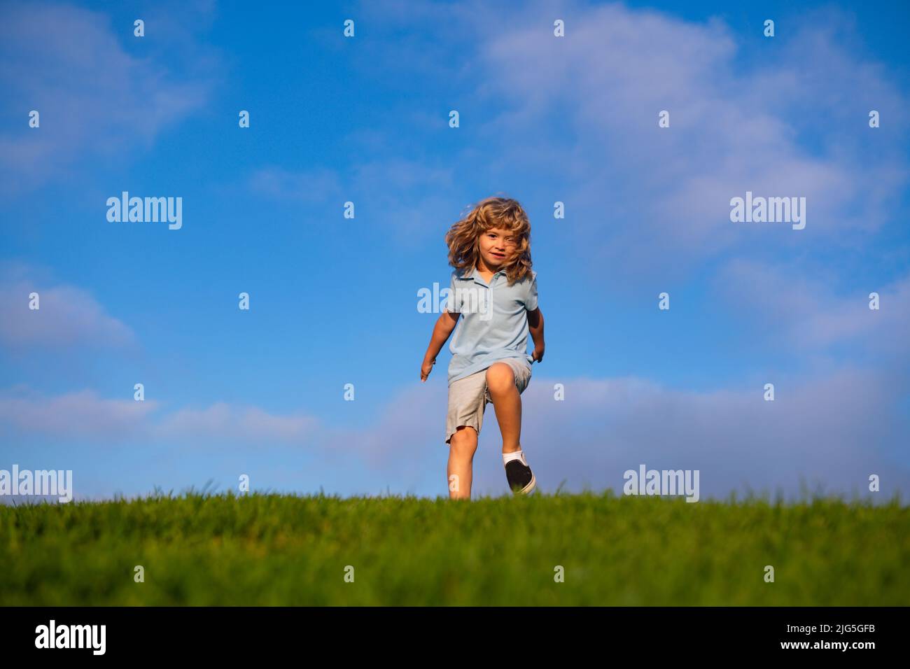 Child boy running on meadow. Happy kid run on beautiful summer field ...