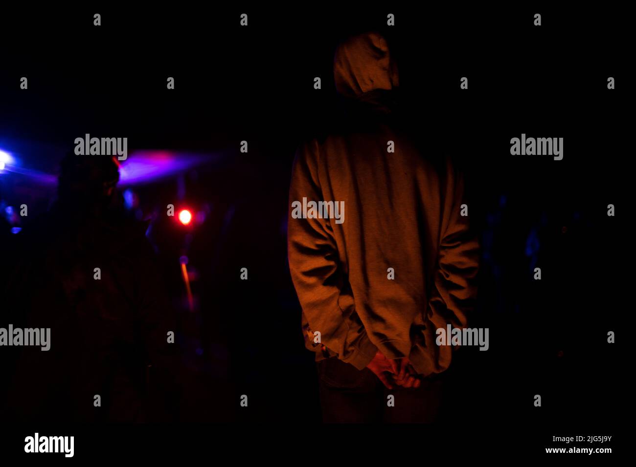 Guy at disco at night. Guy stands with his back at concert. Man in ...