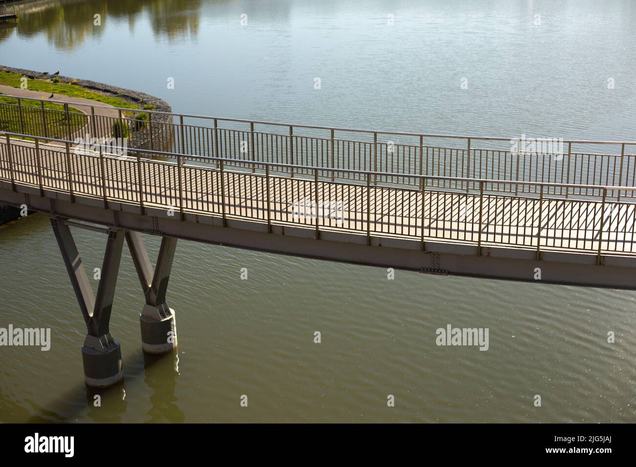 Pedestrian bridge on water. Bridge with railings. Details of park in ...