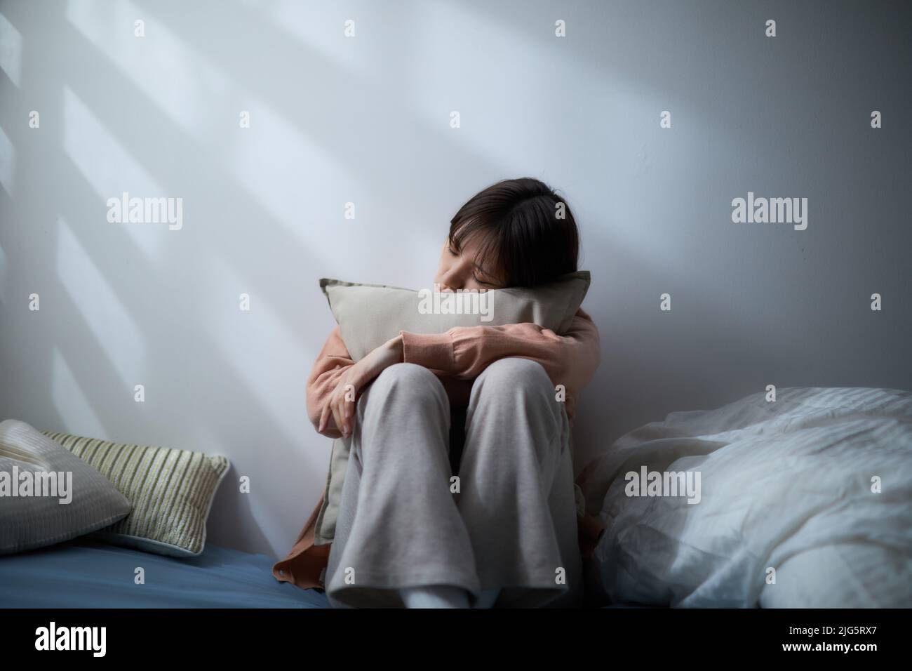 Woman crouching in pain hi-res stock photography and images - Alamy