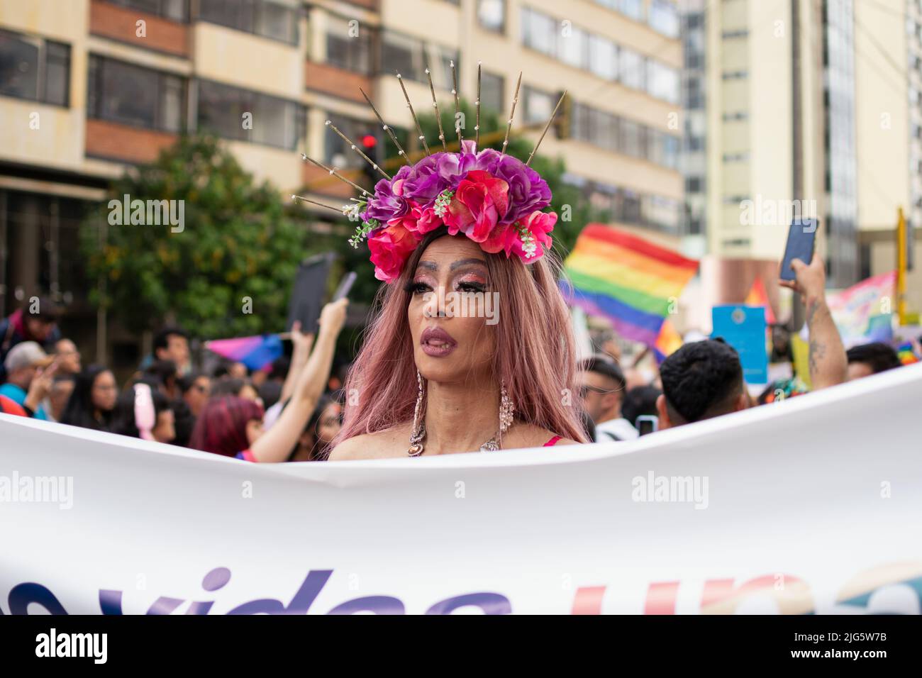 Trans woman with a crown of flowers parades during pride celebration in ...