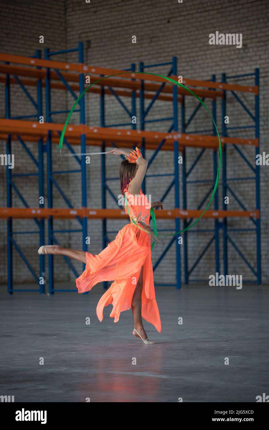 Young woman circus permomer dancing with gymnastic ribbon in hands in ...