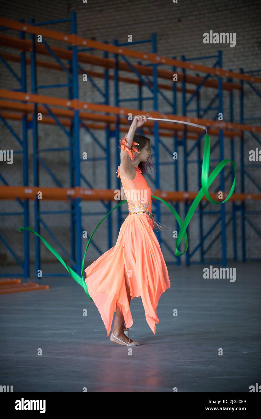 Young fit woman dancing with gymnastic ribbon in hands indoors Stock ...