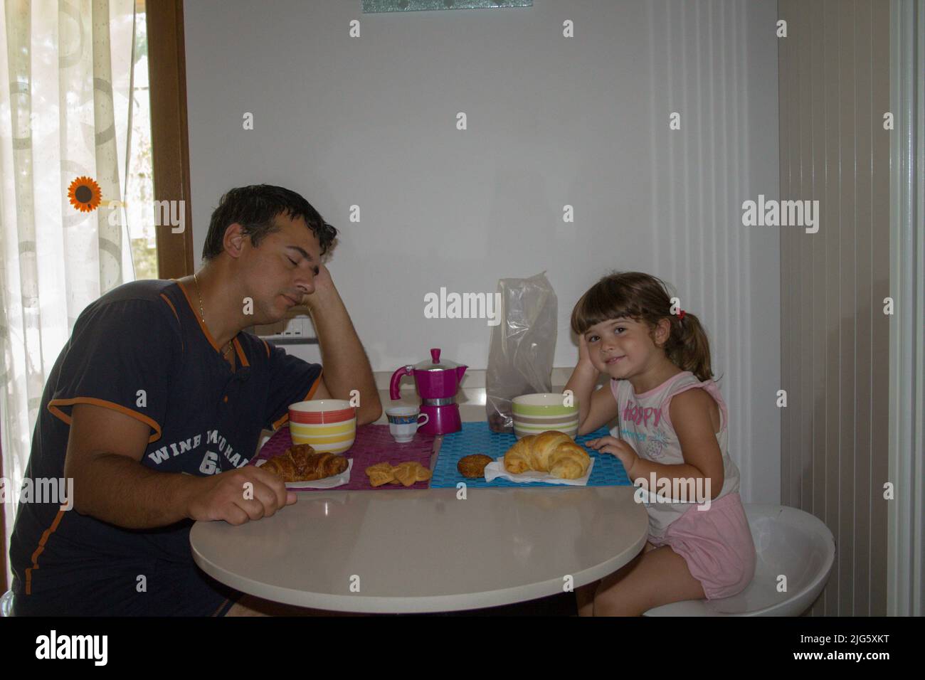 Picture of a sleepy and just waking up dad with his daughter while ...