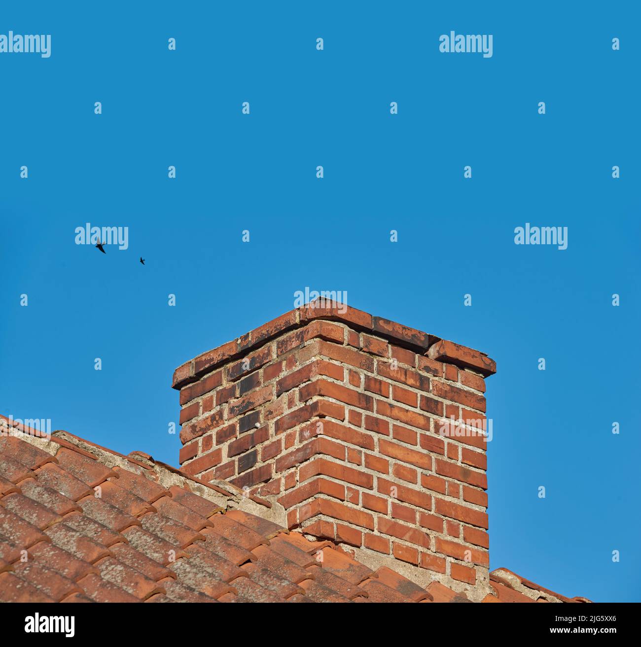 Copy space with a chimney on the roof of a building against a clear ...