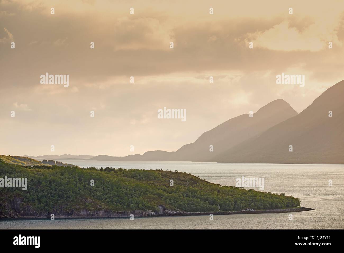 Green hills by the seaside with a sunset sky in Norway. Wild vibrant ...