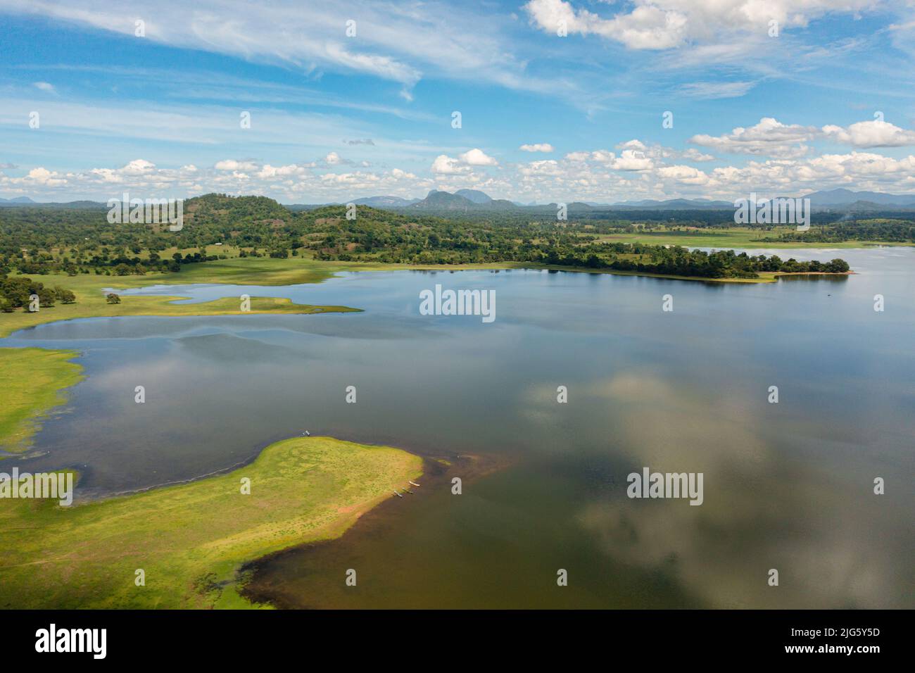 A valley with a lake and tropical vegetation against a blue sky and ...
