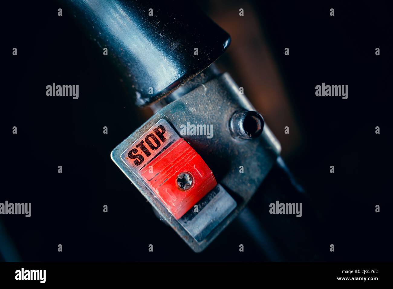 Red color switch button with the inscription stop close-up on a dark ...