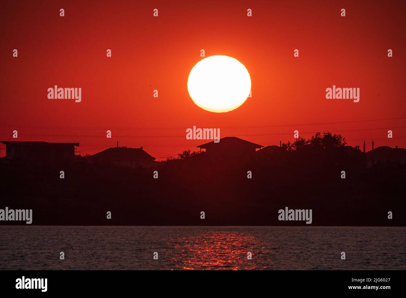 The sun goes down over a lake. Dramatic Sunset Sky Stock Photo - Alamy