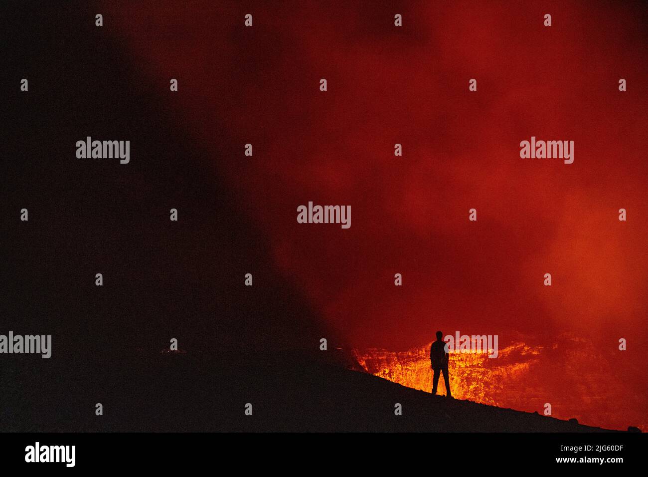 An explorer poses by the crater rim edge as he looks into the Murum ...