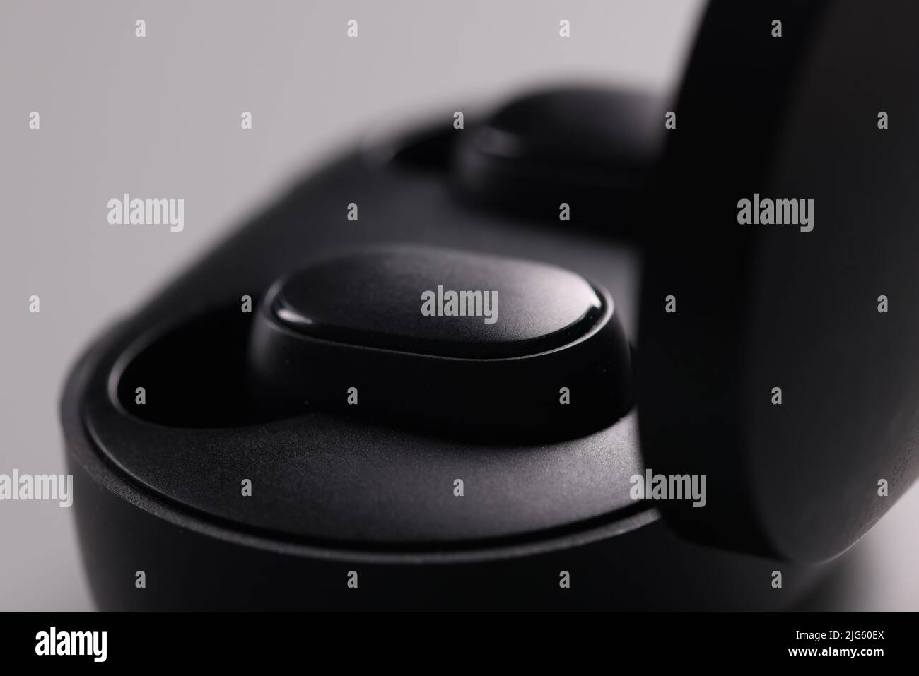 Black electronic bluetooth headphones and technical cases on grey ...