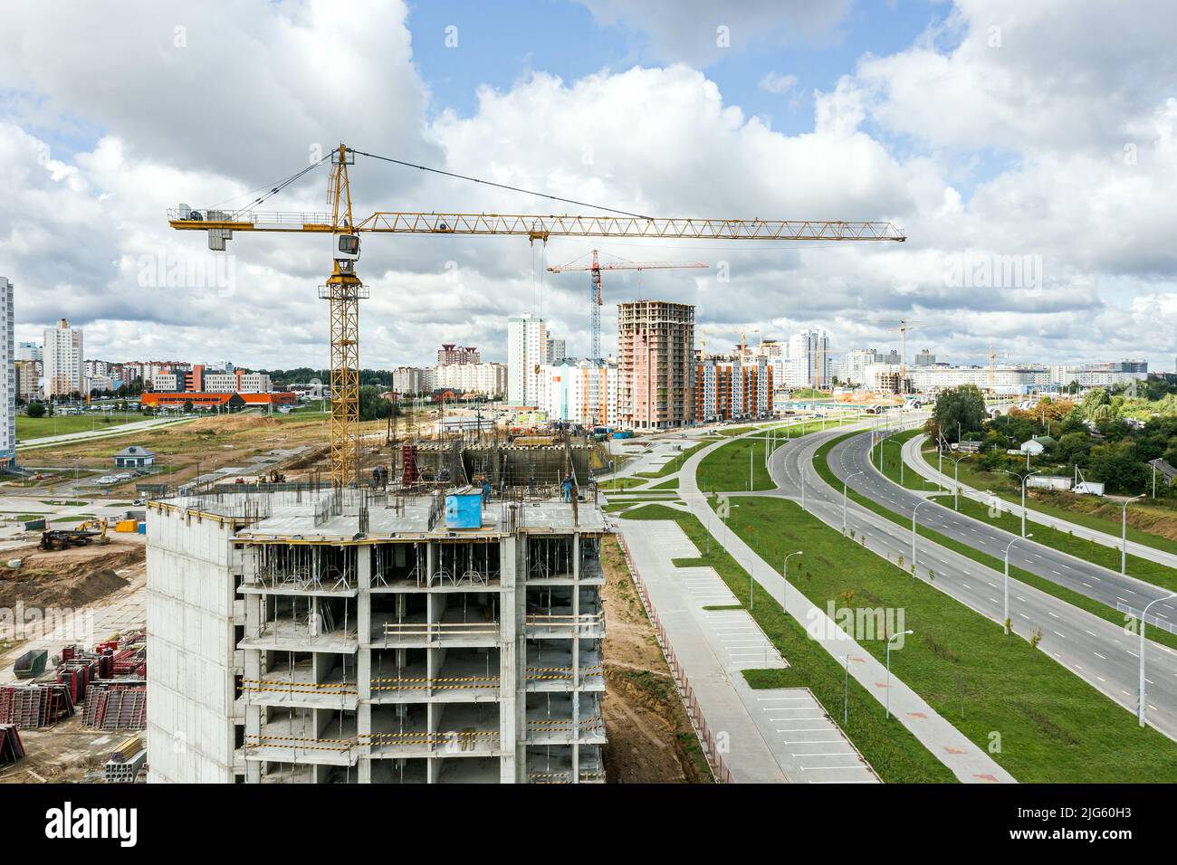 yellow crane near high-rise apartment building under construction ...