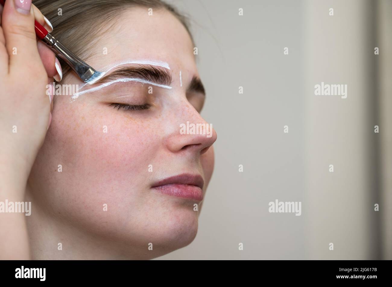 The master draws the shape of the eyebrows with white paint before ...