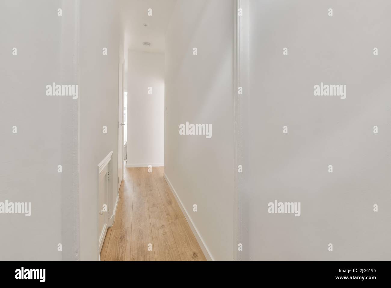 Interior of narrow corridor with many doors and classic painting on ...