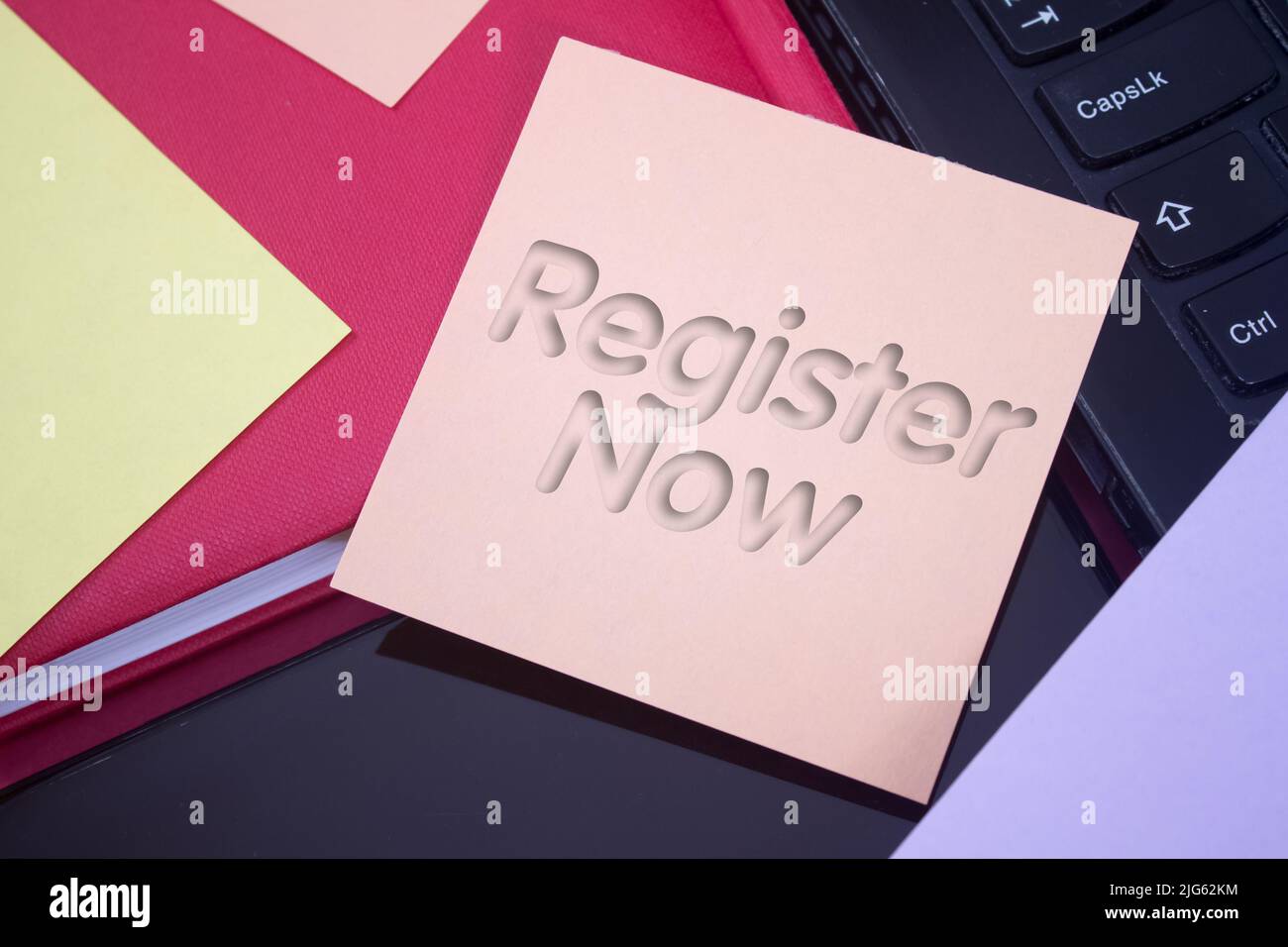 Register Now. Text on adhesive note paper. Event, celebration reminder ...