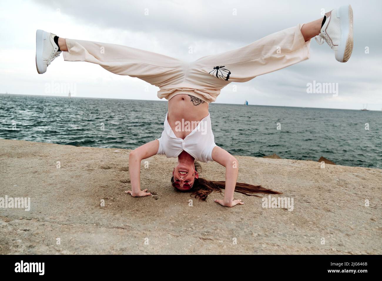 Young hip-hop dancer doing a handstand move while dancing outdoors ...