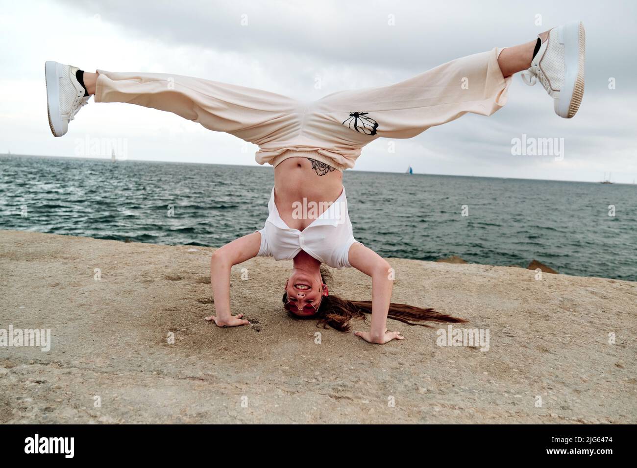 Hip-hop dancer make a handstand dance move while breakdancing outdoors ...