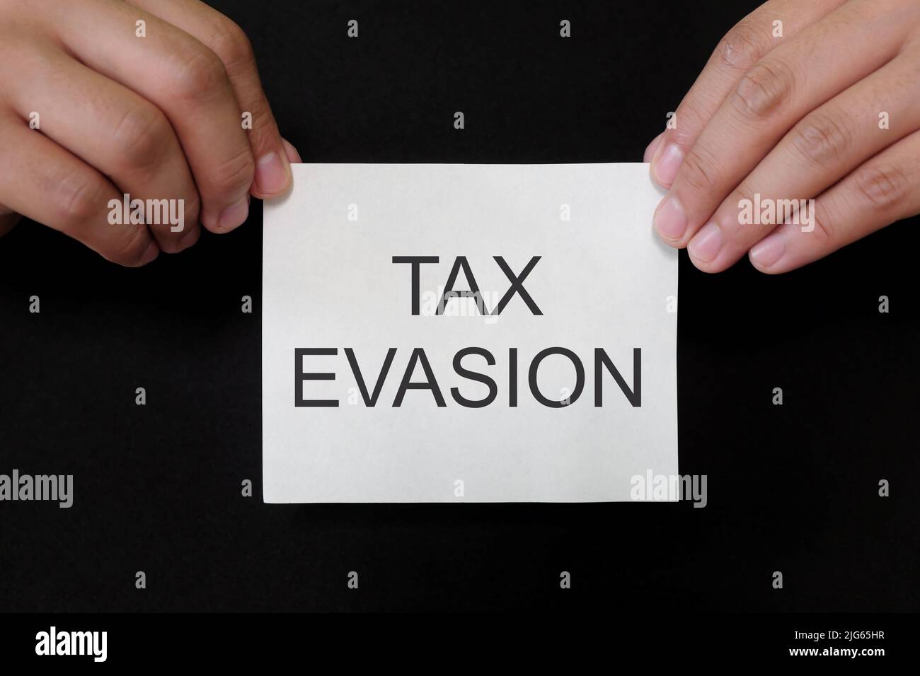 Tax evasion mug shot concept. Criminal hands holding paper placard with ...