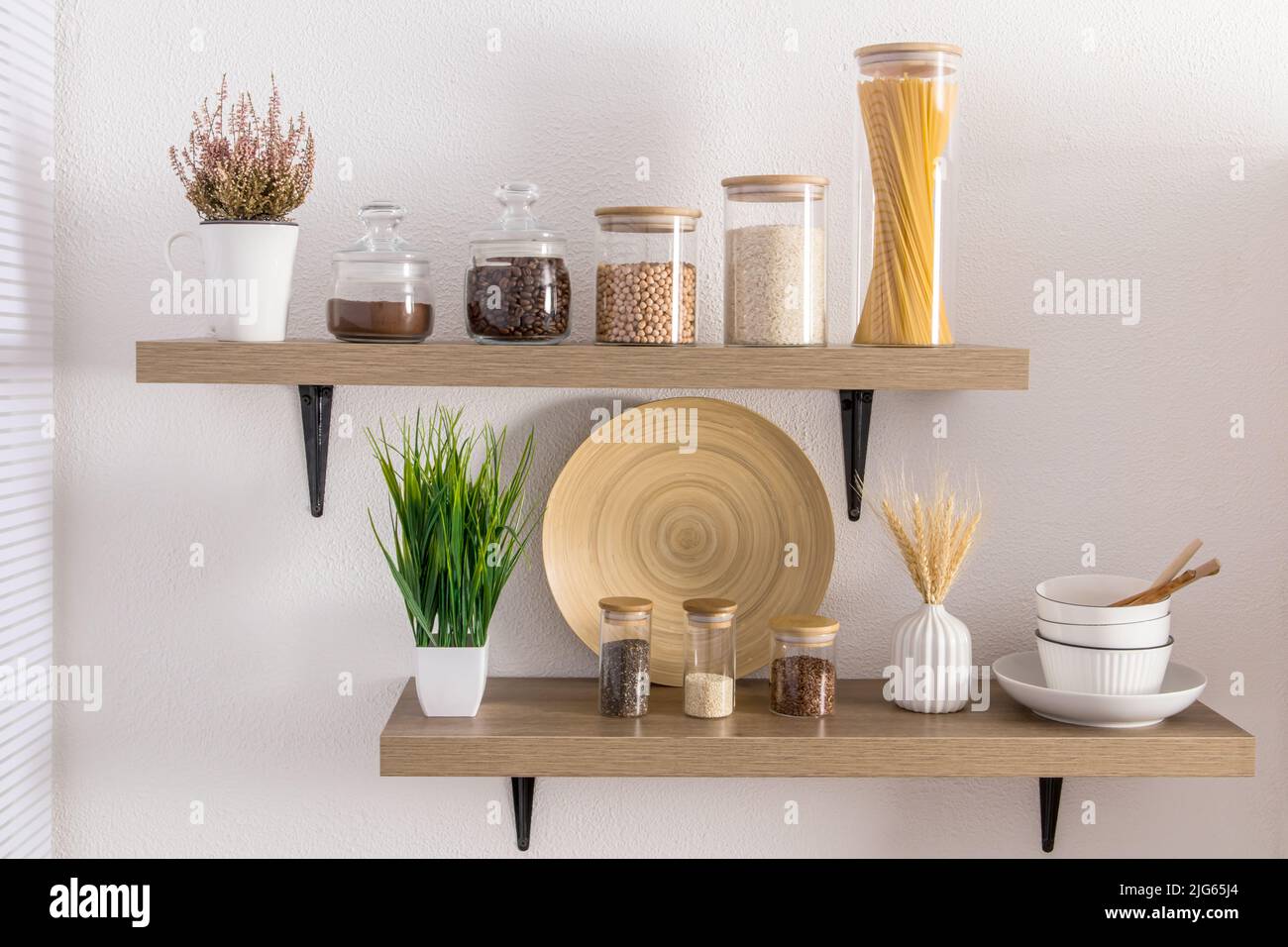 Front view of stylish open kitchen shelves with various eco-jars under ...
