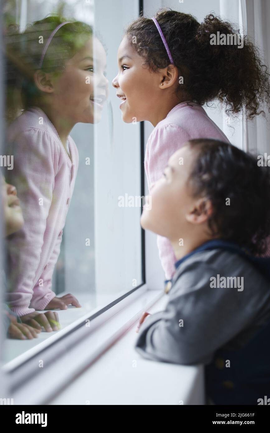 Its time to play outside. Shot of two little sisters looking out the ...