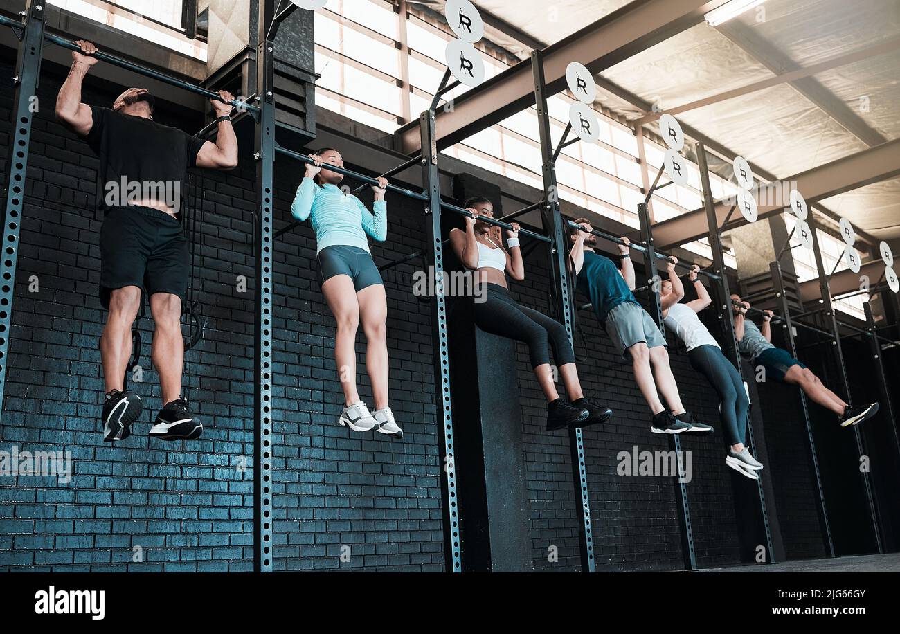 As many reps as we can. Shot of a group of people completing pull ups ...