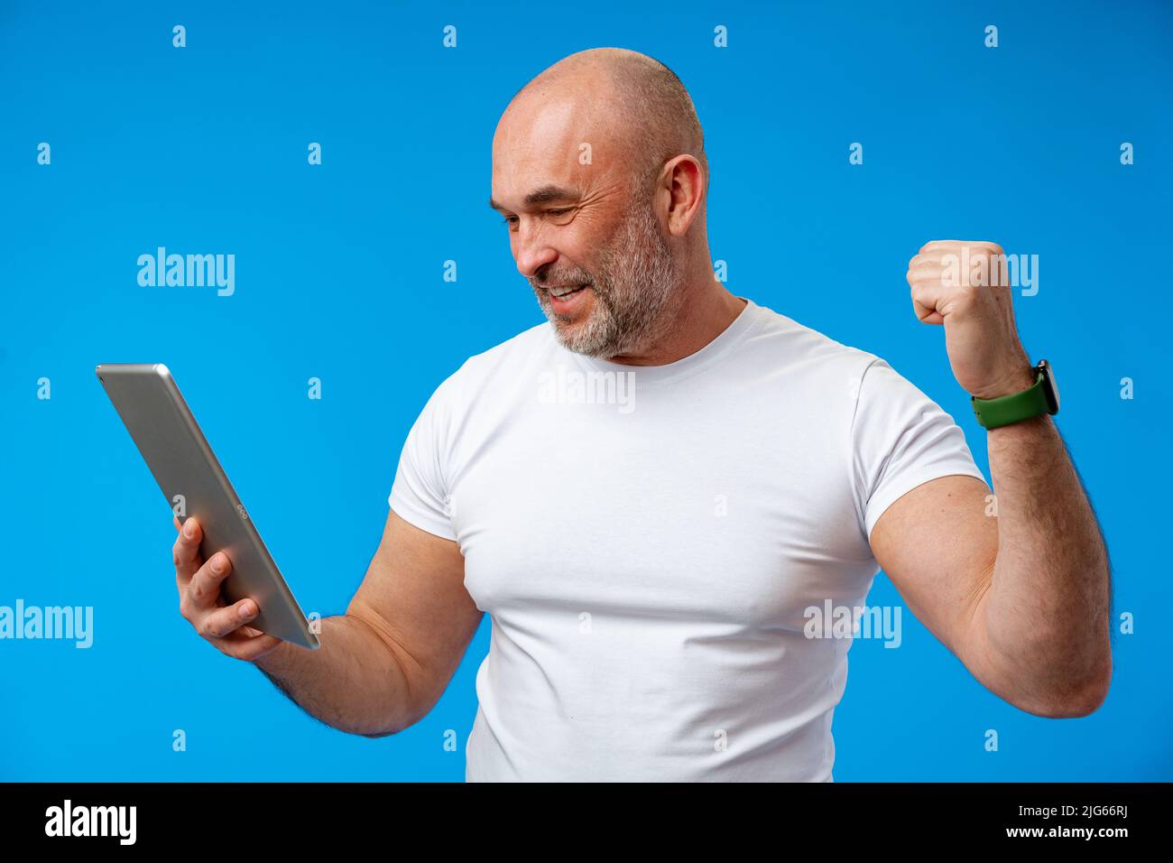 Handsome middle age man with digital tablet against blue background ...