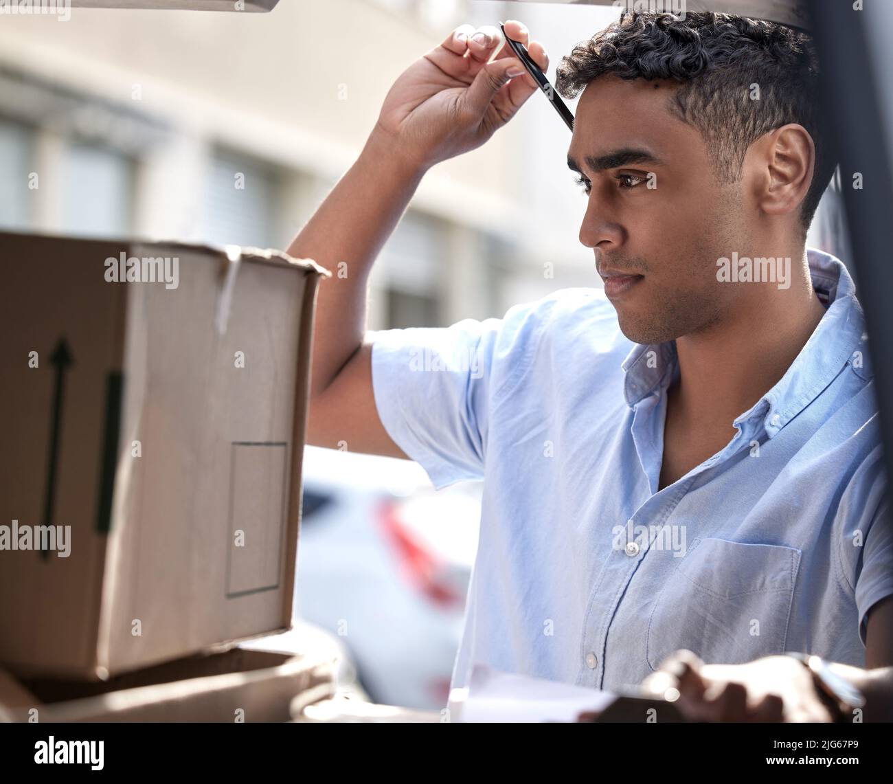 Am I missing a box. Shot of a young delivery man checking boxes in a ...
