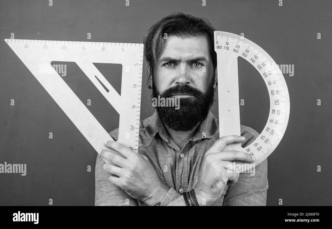 formal education. measure and size. serious teacher hold triangle and ...