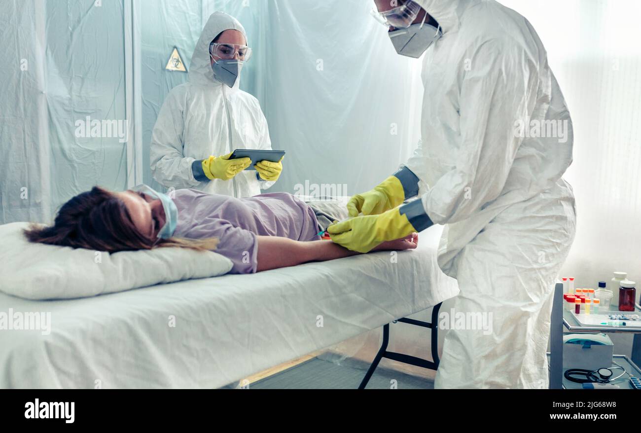 Doctors taking blood sample from patient lying on a gurney Stock Photo ...
