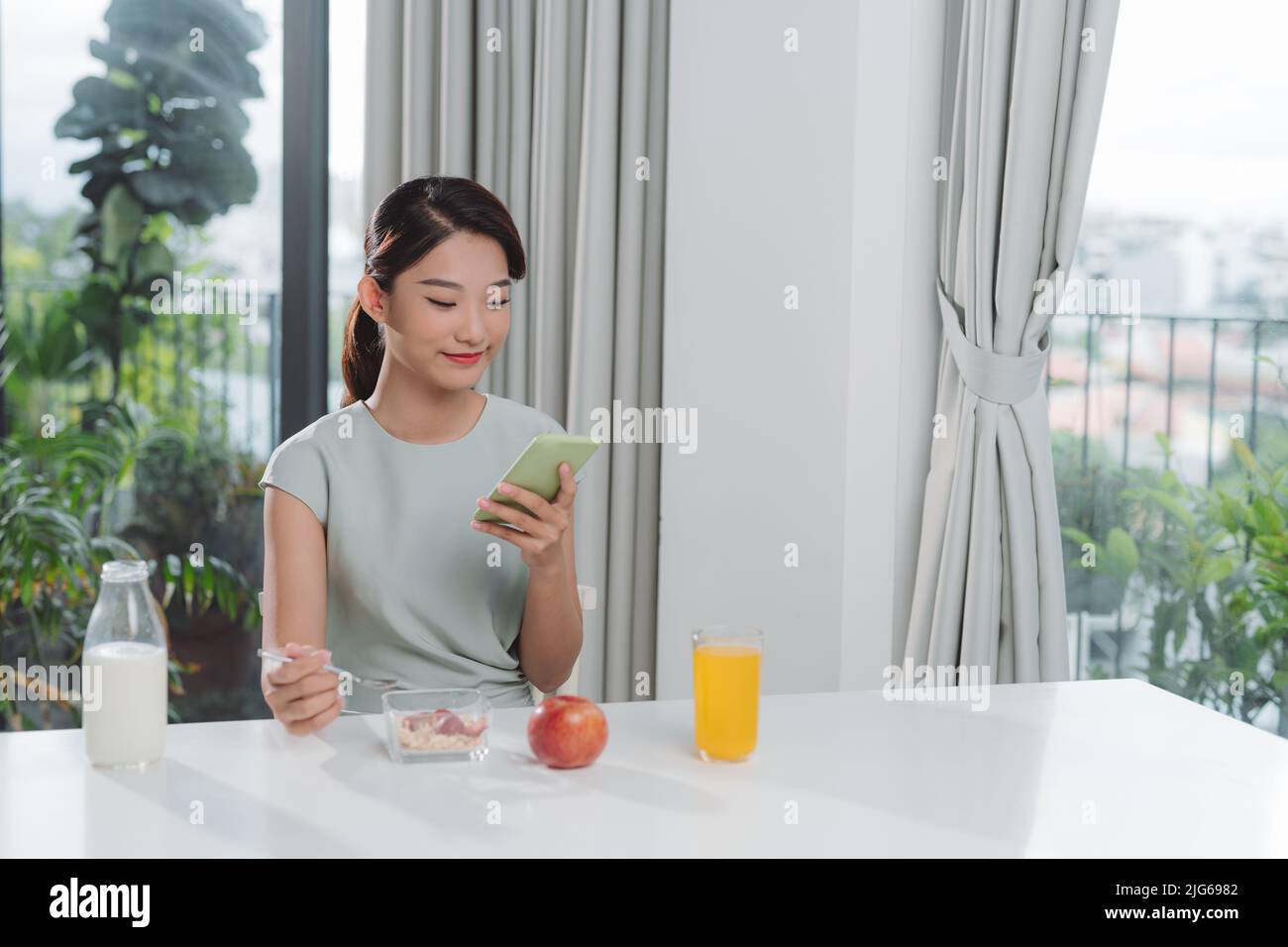 a asian woman eating and being distracted by social media Stock Photo ...