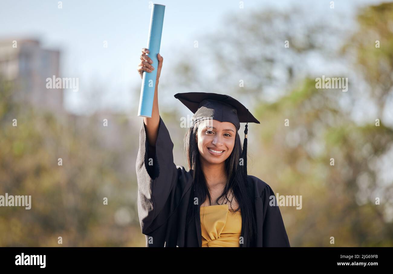 Today is graduation day. Portrait of a young woman holding her diploma ...