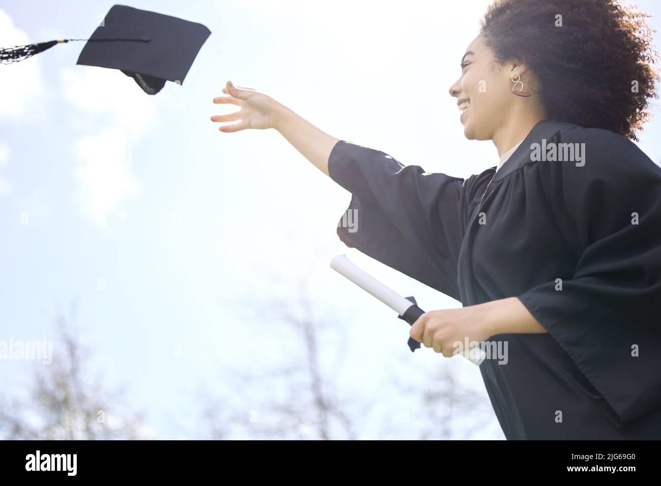 Go out there and do amazing things. Shot of a young woman tossing her ...