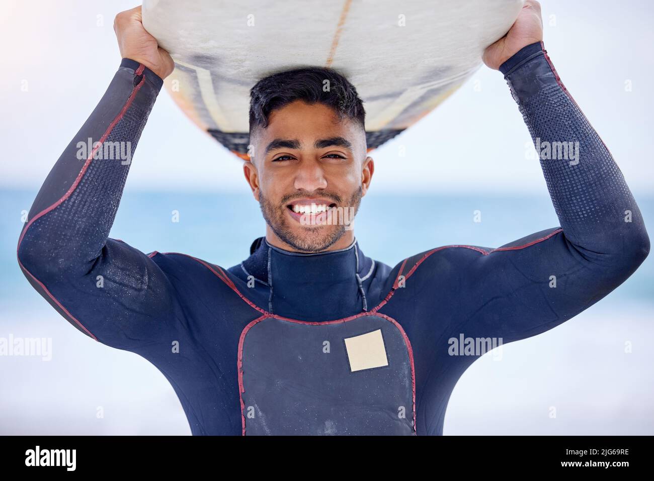 Surfing is my philosophy 101. Portrait of a handsome young man carrying ...