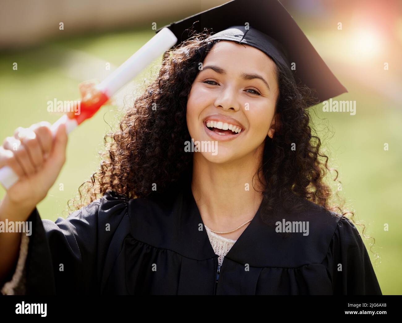 I earned this. Portrait of a young woman holding her diploma on ...