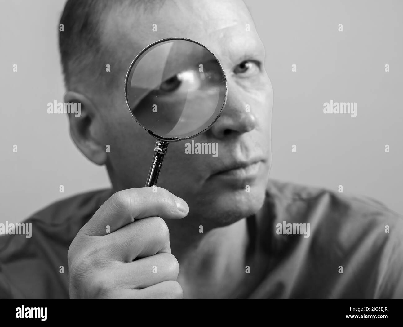 Man looking through magnifying lens glass portrait, investigating ...