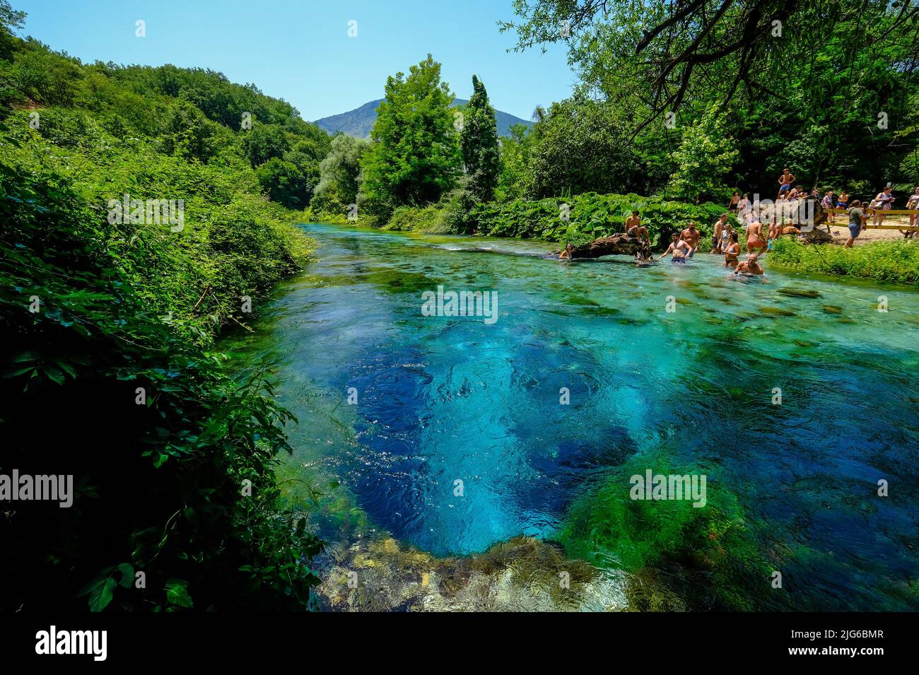 Muzina, Albania - Tourists bathe in the Syri i Kaltër, THE BLUE EYE, is ...