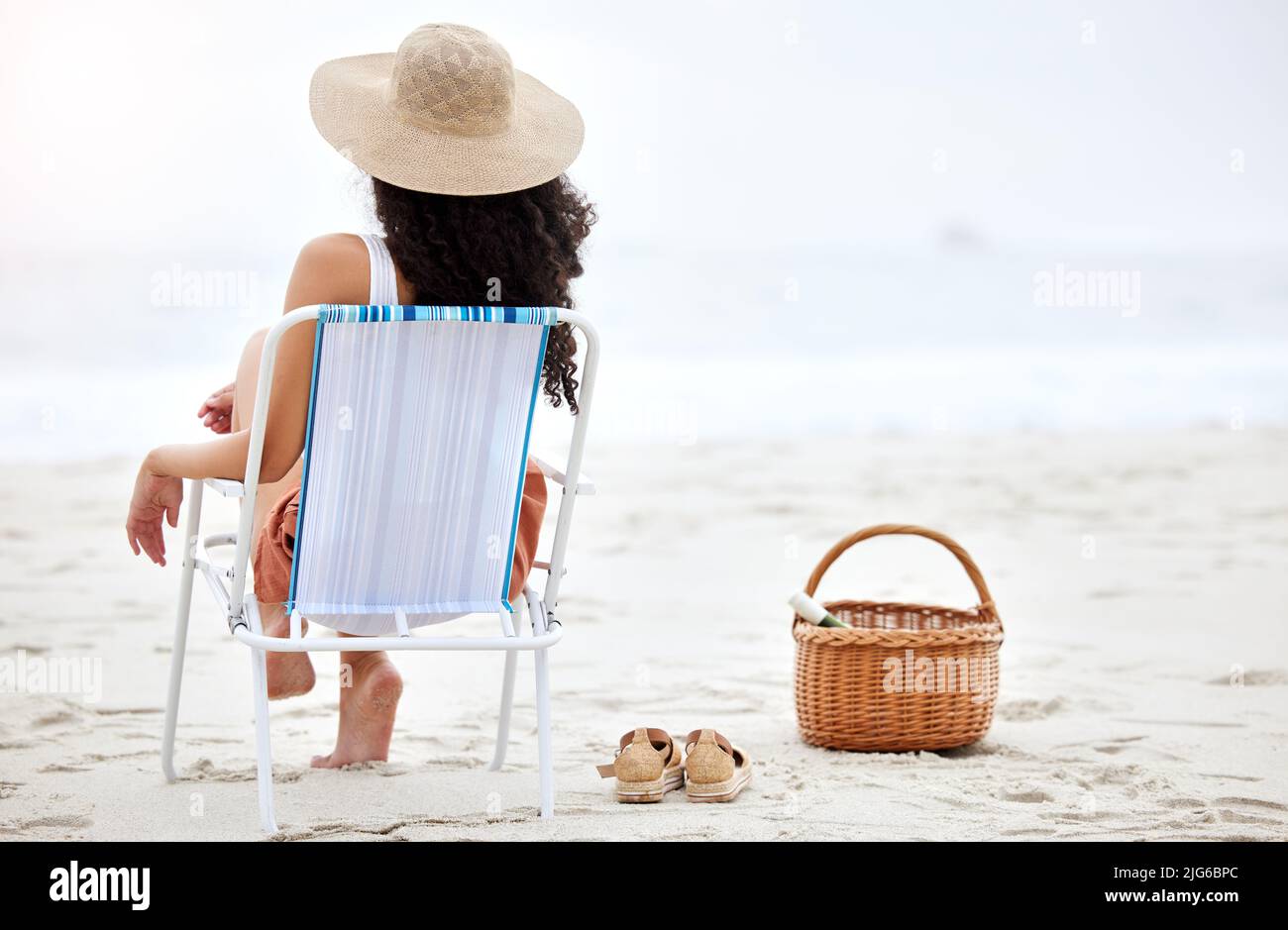 Its a perfect beach day. Shot of a young woman enjoying a day at the ...