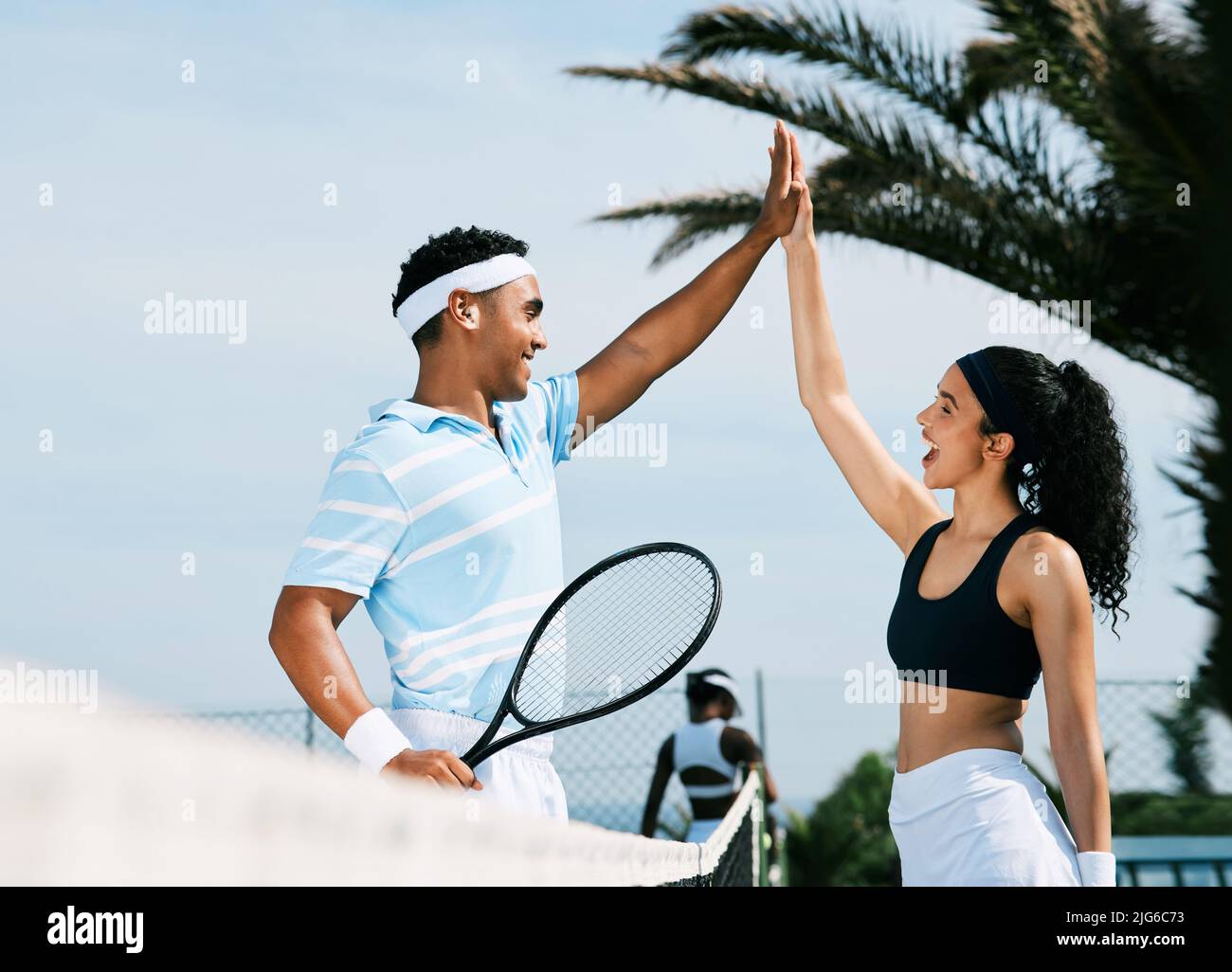 Well done. Shot of tennis teammates sharing a high five during a tennis ...