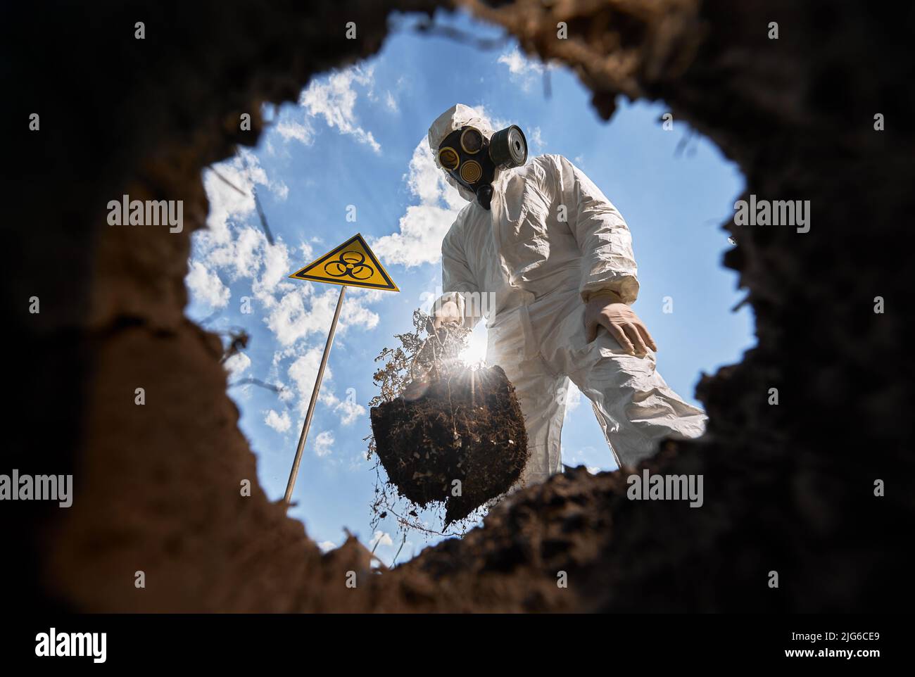 View from inside pit of ecologist digging pit by shovel and planting ...