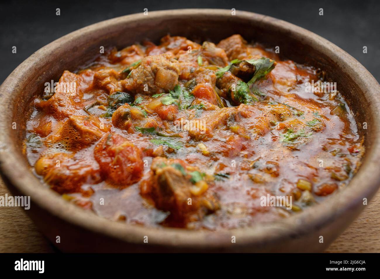 Georgian national dish Ojakhuri, in a clay plate, on a wooden board, on ...