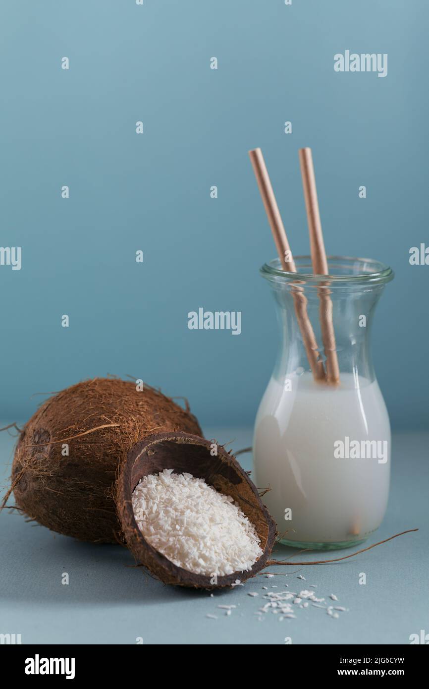 Bottle of coconut vegan milk with straws, whole coconut and flakes ...