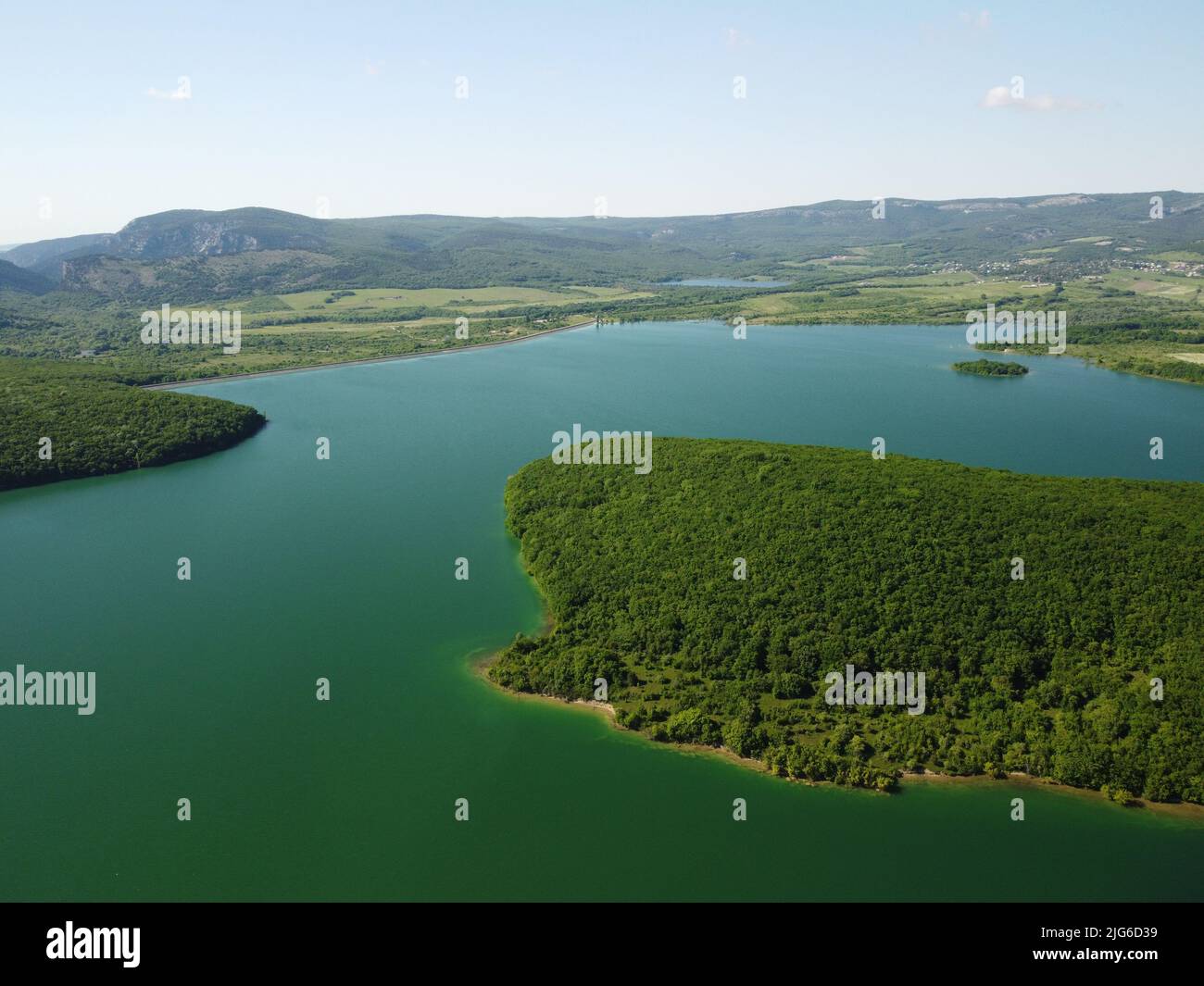 Aerial view on water reservoir at mountain valley covered with green ...